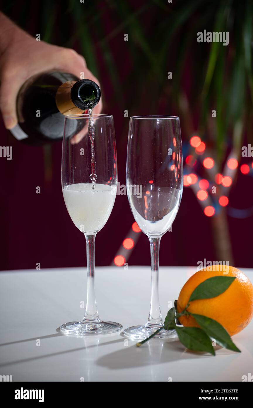 Pouring of brut champagne, cava or prosecco dry wine in glasses with ...