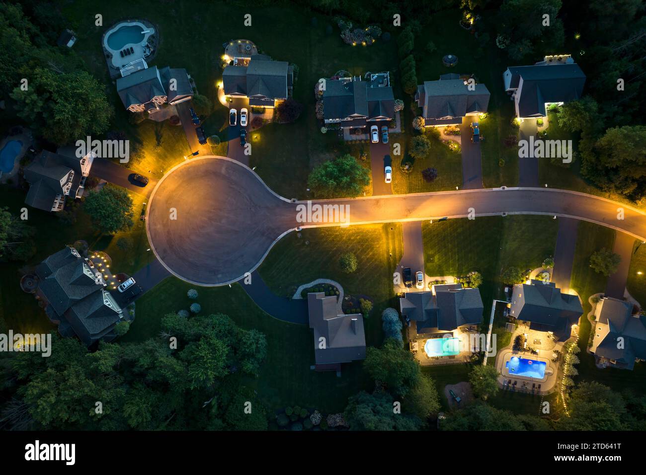 Residential illuminated homes at night in suburban sprawl development ...