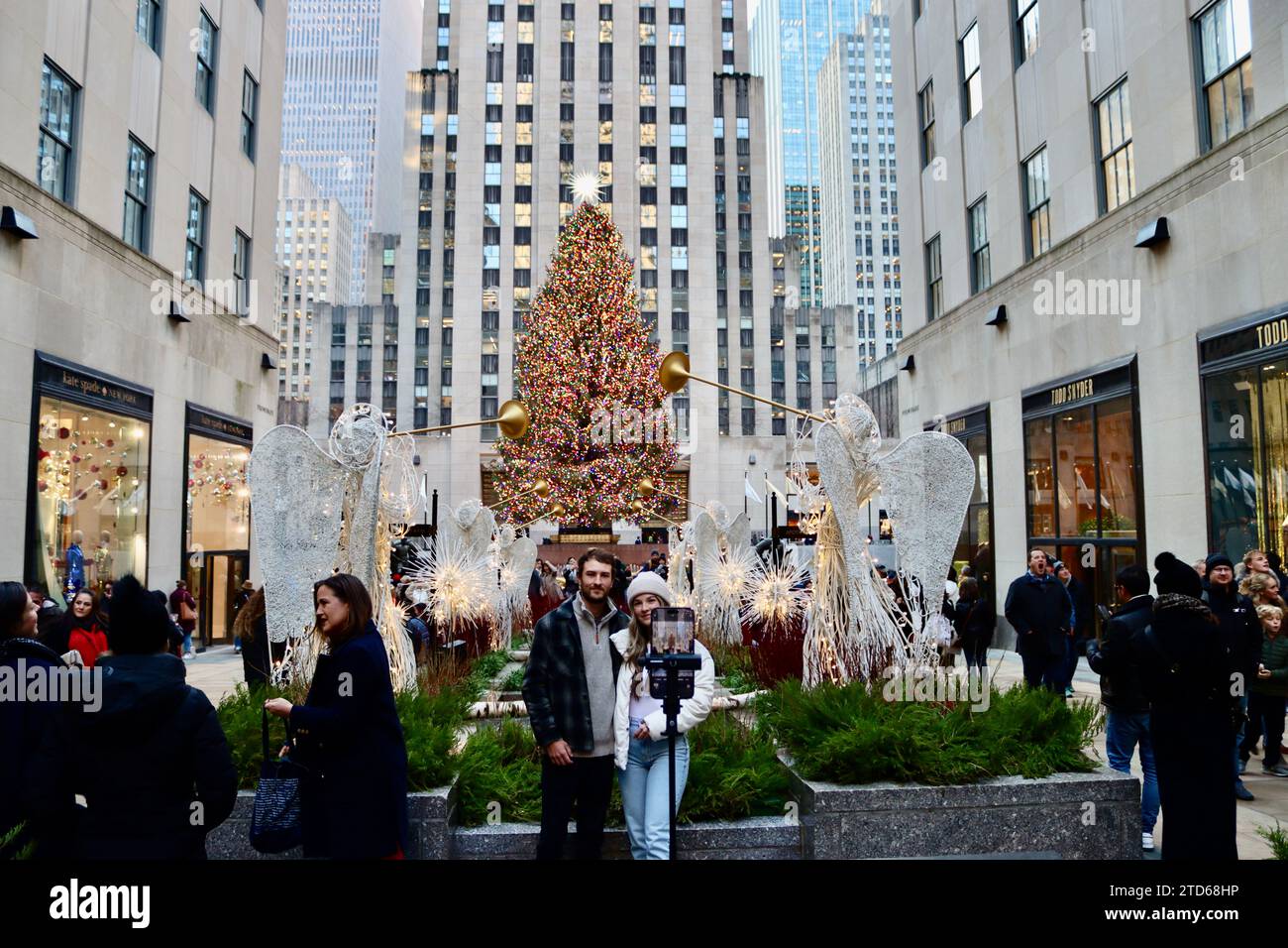 Young couple taking selfies in front of the Christmas tree at the ...