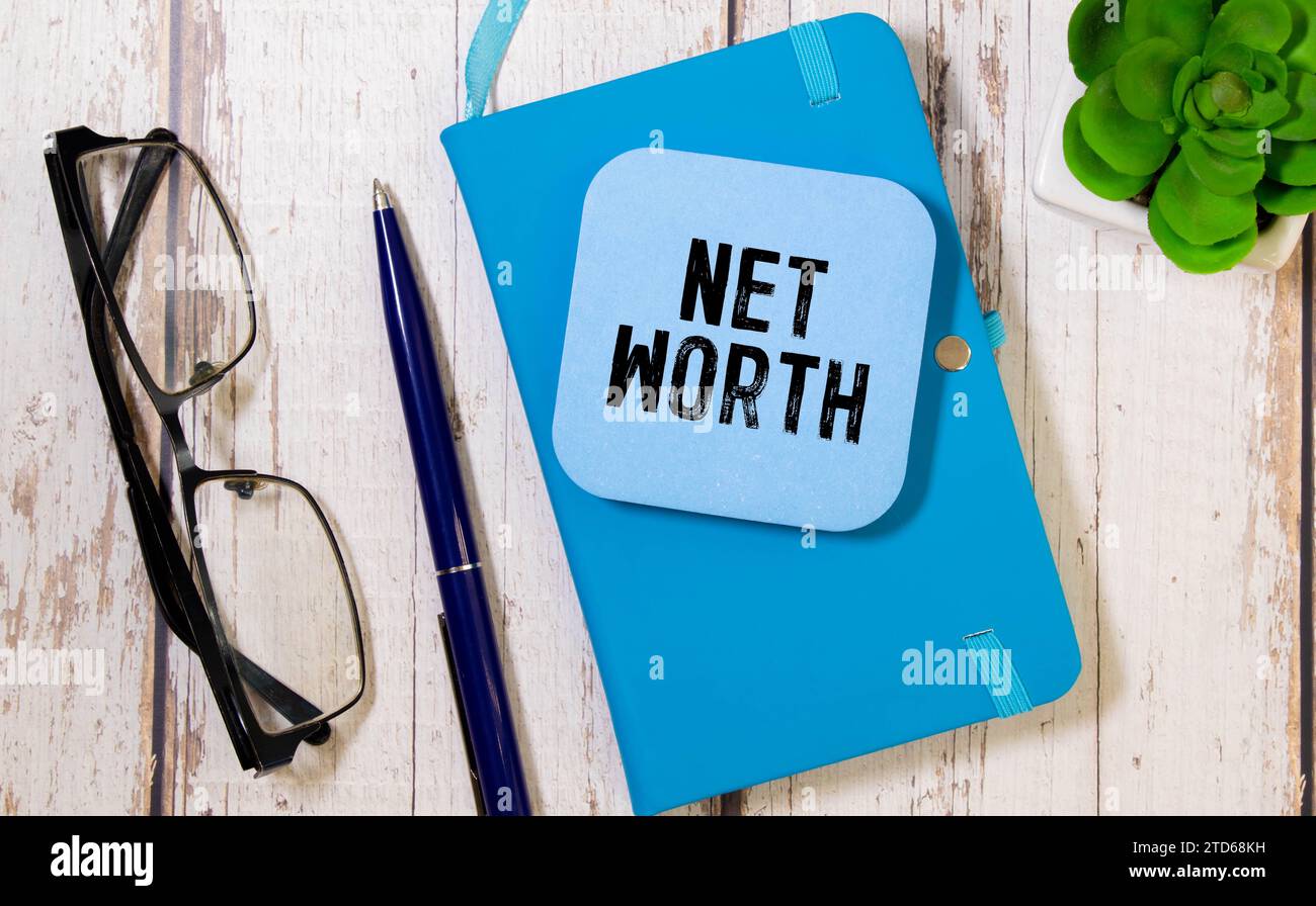 NET WORTH text on a notepad on chart with keyboard and calculator on ...