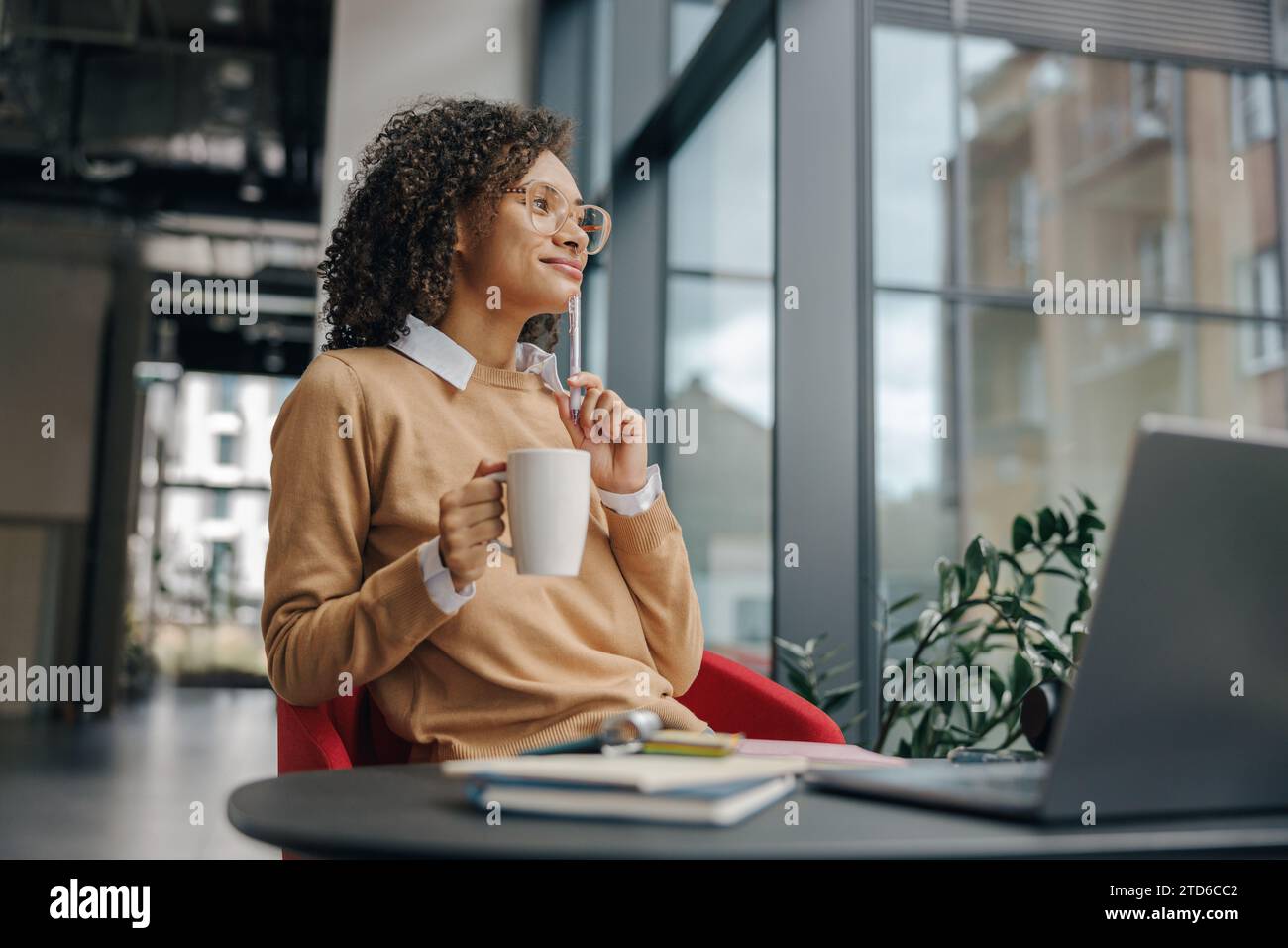 Smiling female manager have coffee break during working on laptop in ...