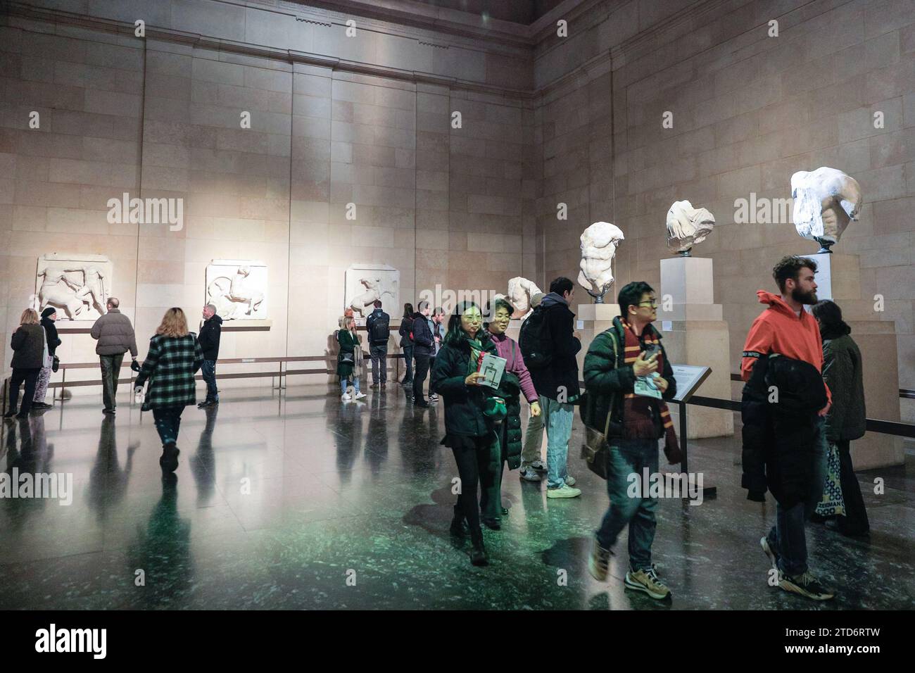 London, UK. 16th Dec, 2023. Tourists and visitors admire sculptures from the west pediment ...