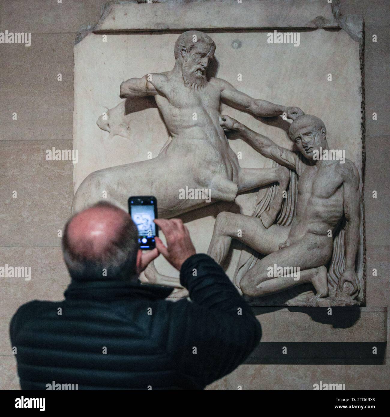 London, UK. 16th Dec, 2023. Tourists and visitors admire sculptures from the east pediment ...