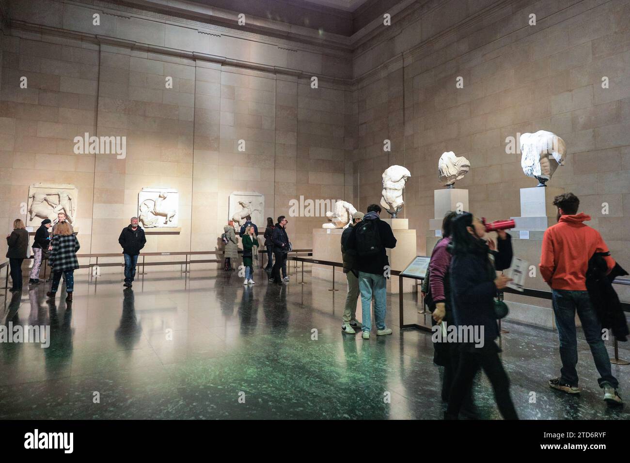 London, UK. 16th Dec, 2023. Tourists and visitors admire sculptures from the west pediment ...