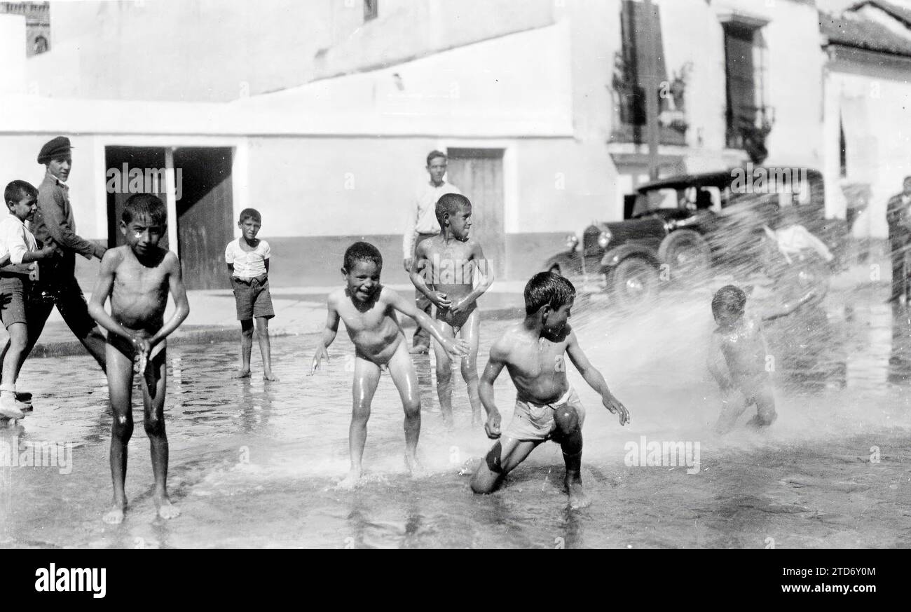 Seville, July 1930. Group of boys taking showers from a watering hose ...