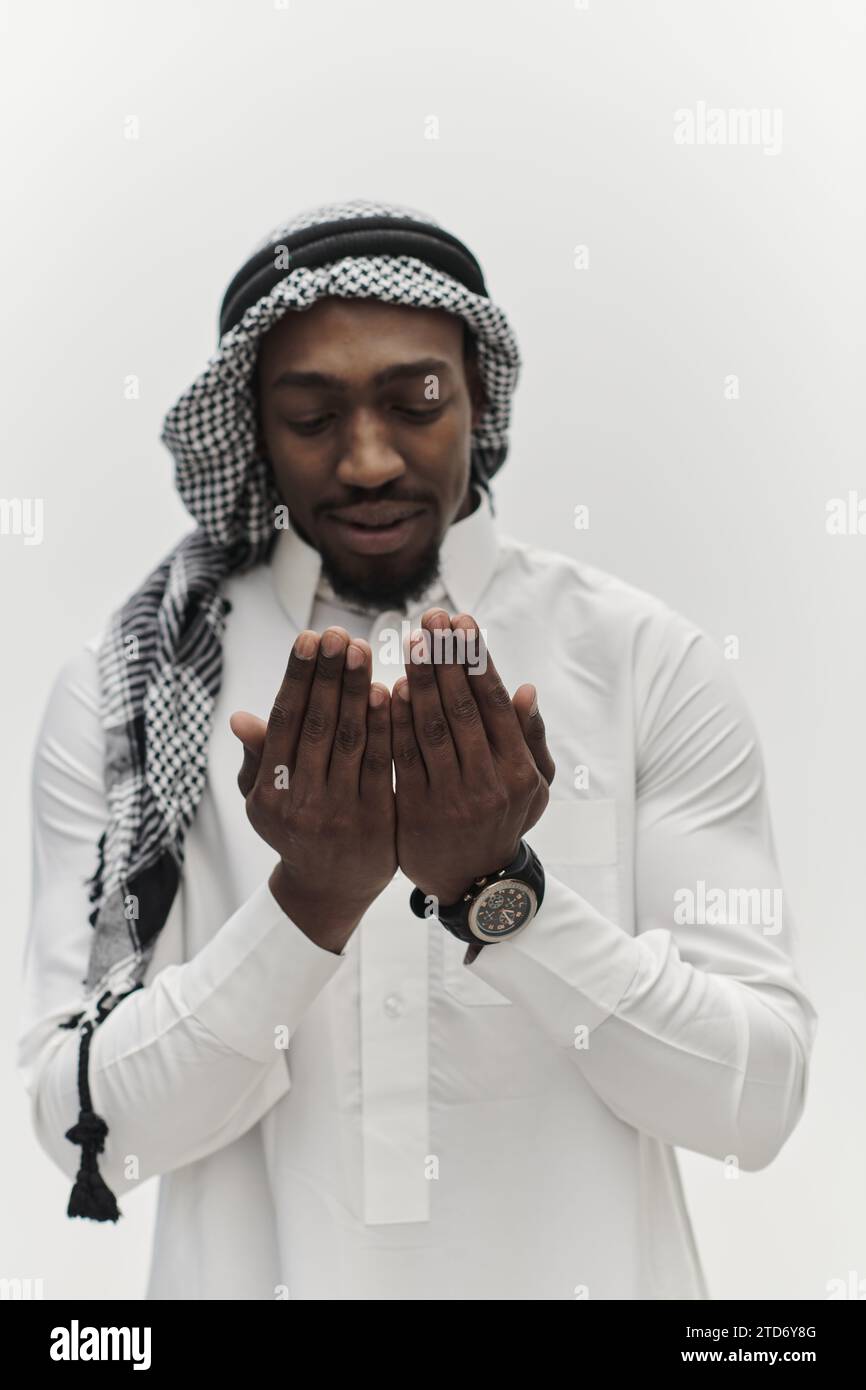 African American Muslim man raises his hands in prayer, seeking solace ...