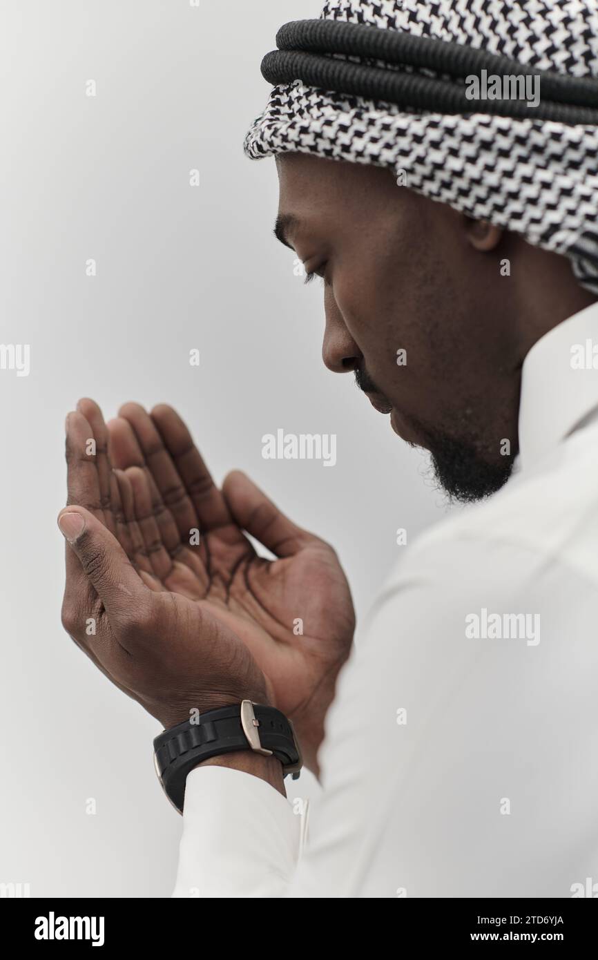 African American Muslim man raises his hands in prayer, seeking solace ...