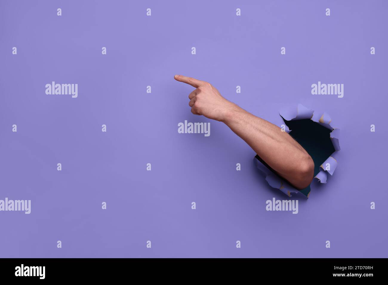 Special promotion. Man pointing at something through hole in purple ...