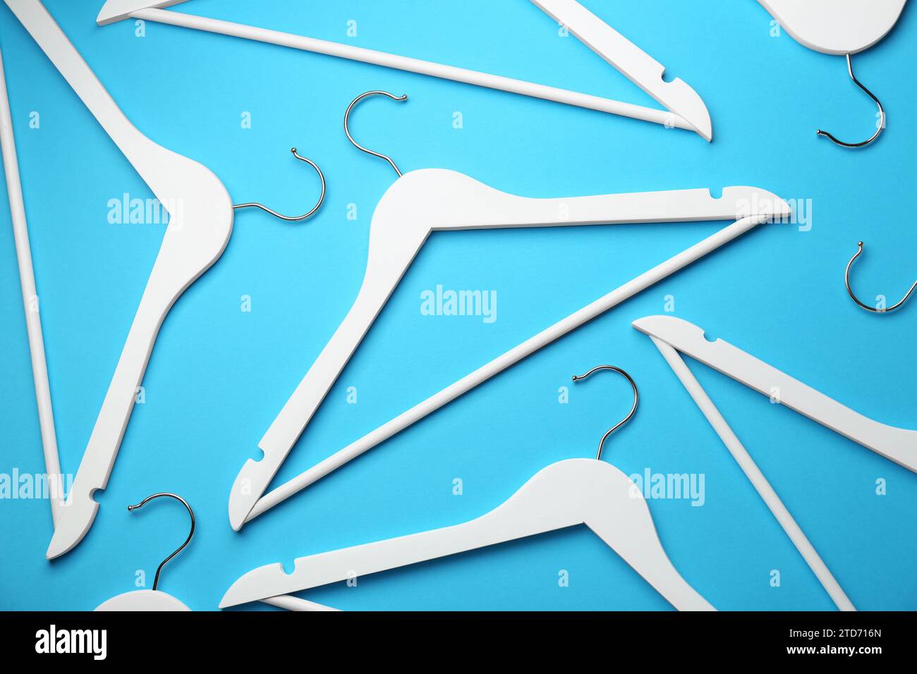 White hangers on light blue background, flat lay Stock Photo - Alamy