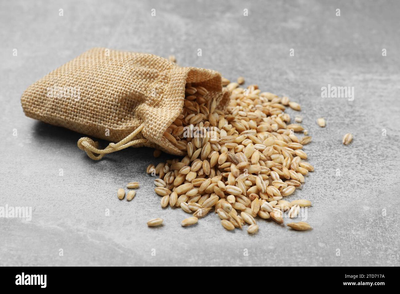 Bag with dry pearl barley on gray table, closeup Stock Photo - Alamy