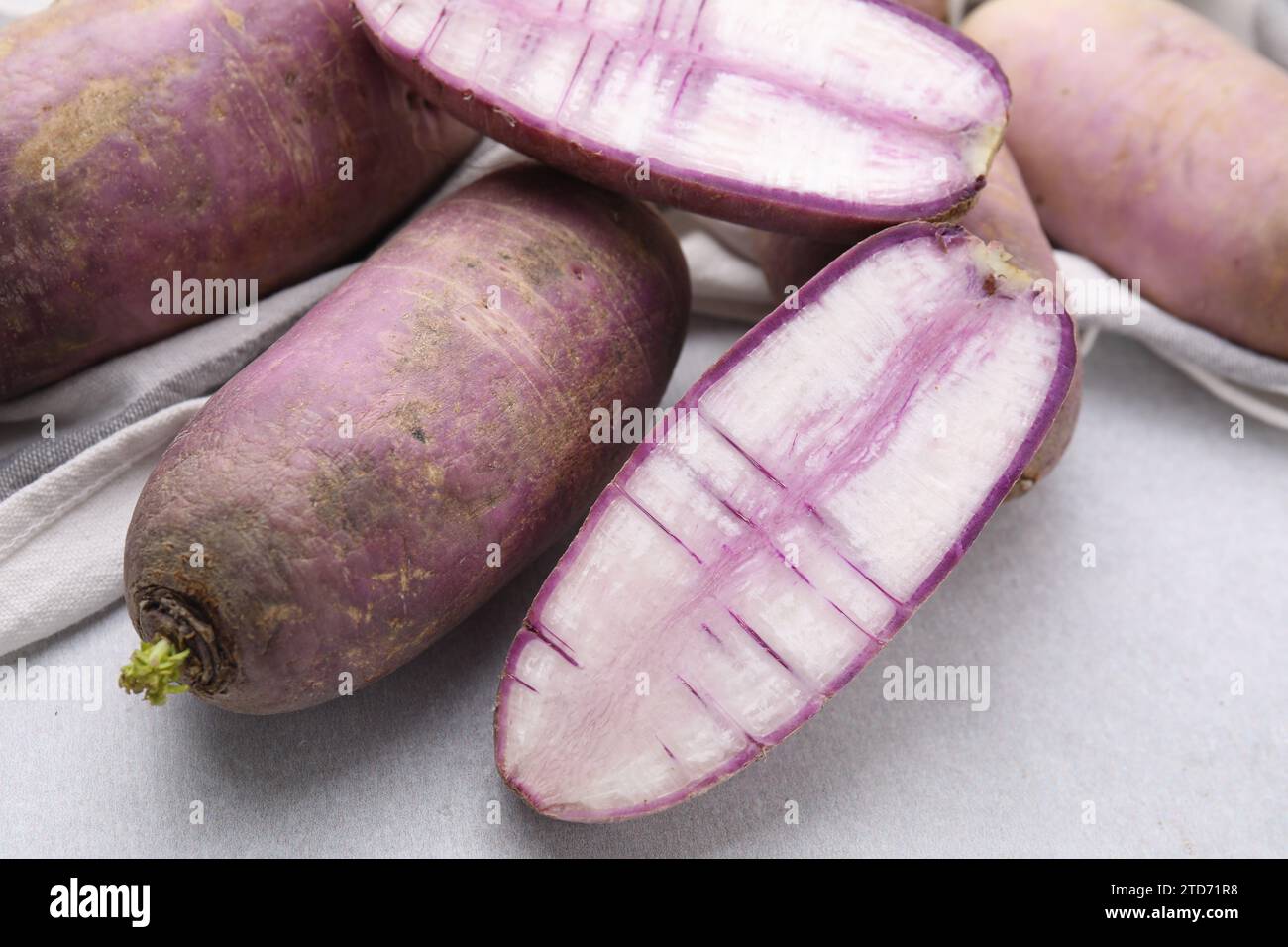Purple daikon radishes on light grey table, closeup Stock Photo - Alamy