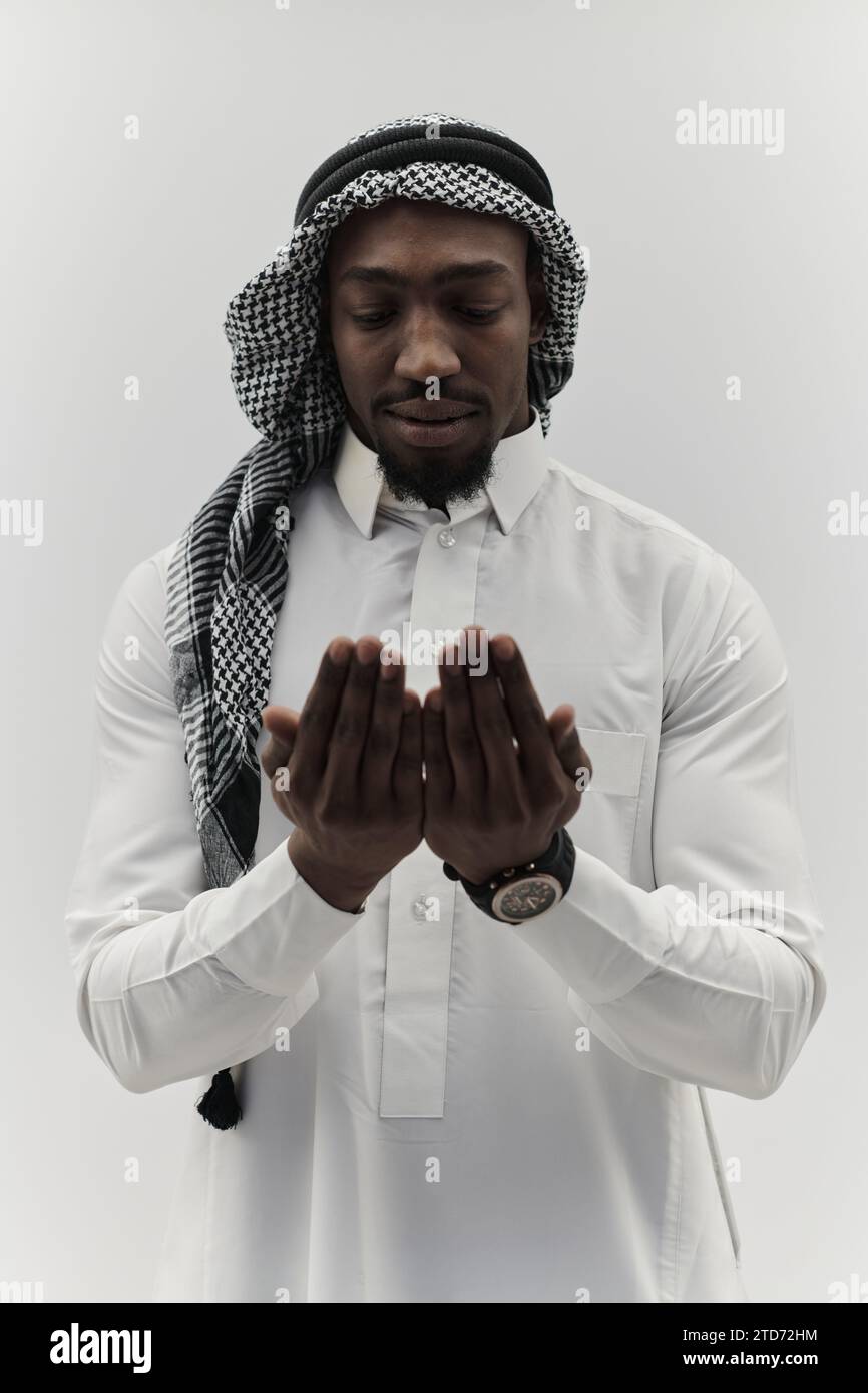 African American Muslim man raises his hands in prayer, seeking solace ...