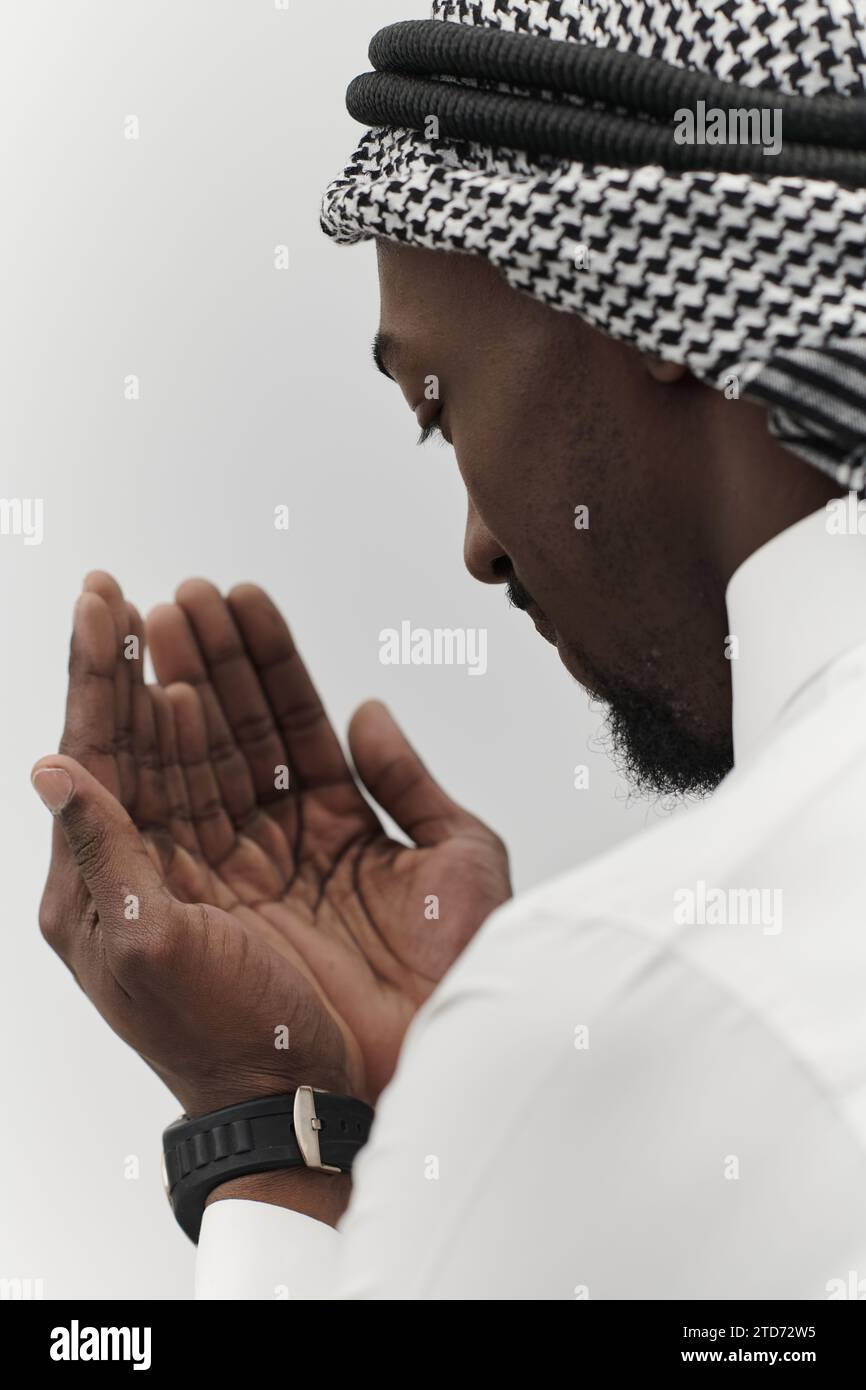African American Muslim man raises his hands in prayer, seeking solace ...