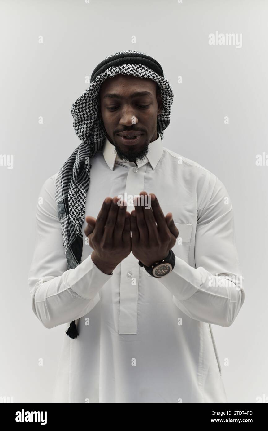 African American Muslim man raises his hands in prayer, seeking solace ...
