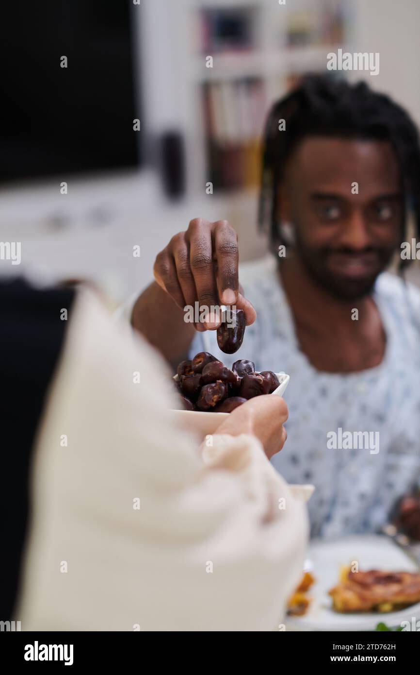 African American Muslim man delicately takes dates to break his fast ...