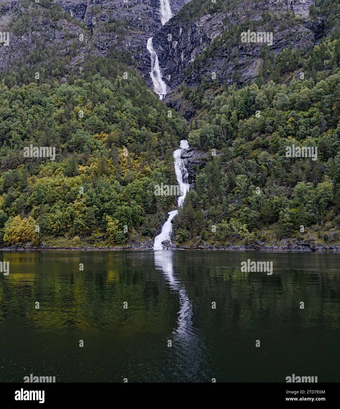 A small waterfalls from the mountain with the reflection in the water ...