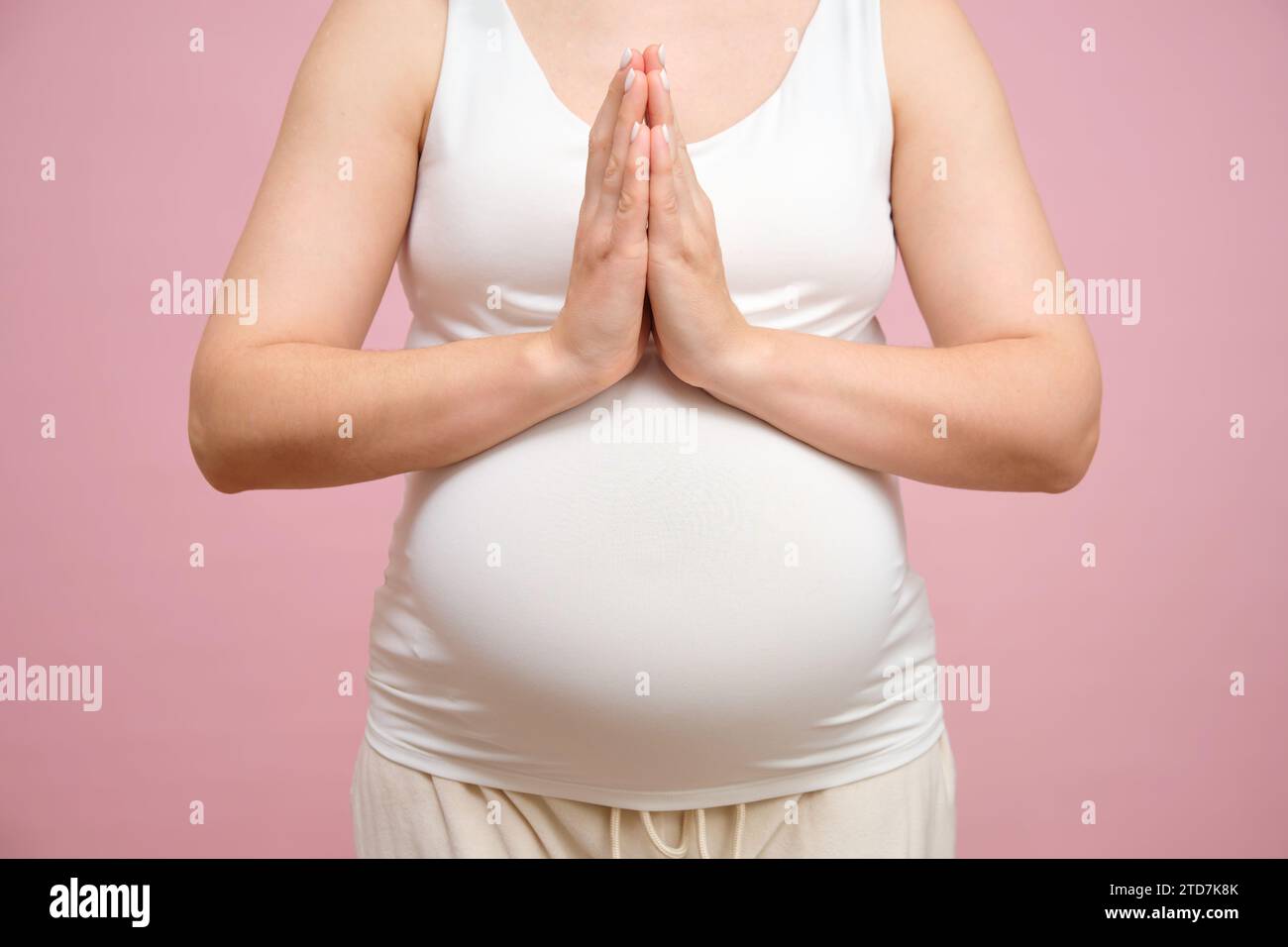 Pregnant woman praying to god with her hands folded in a prayer gesture ...