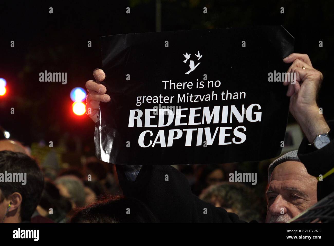 A protestor holds a sign that reads "There is no greater mitzvah than ...