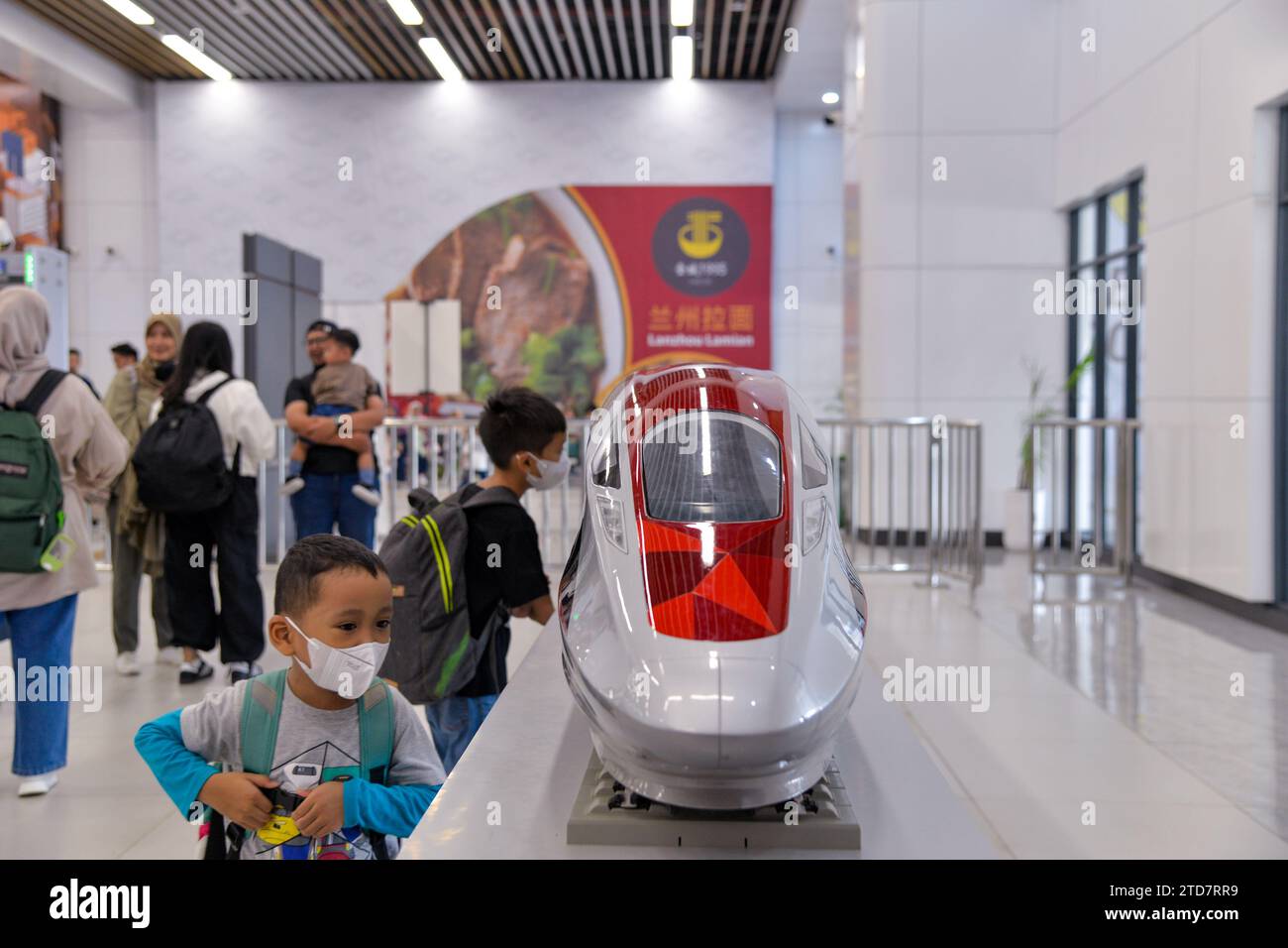 Jakarta, Indonesia. 17th Dec, 2023. Two boys look at a model of a high-speed electrical multiple ...