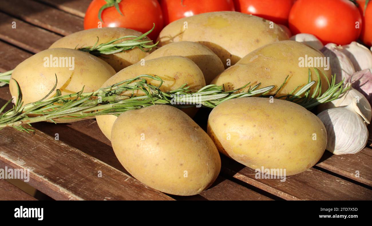 Austrian potatoes with rosemary tomatoes and garlic on a wooden table ...