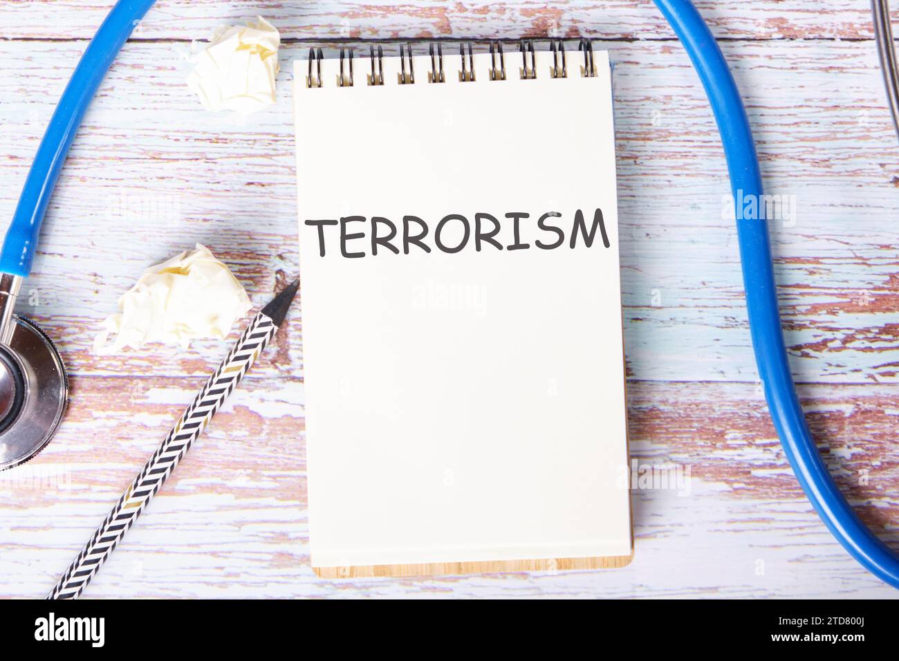 TERRORISM text is written on a notebook that lies on old vintage boards ...