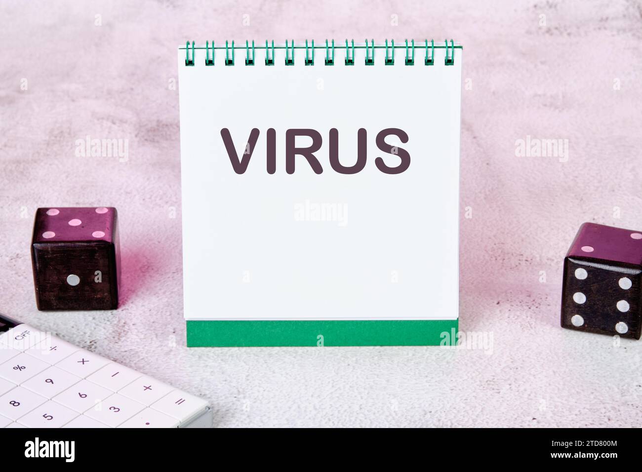 VIRUS text on a white notepad sheet next to dice on an abstract ...