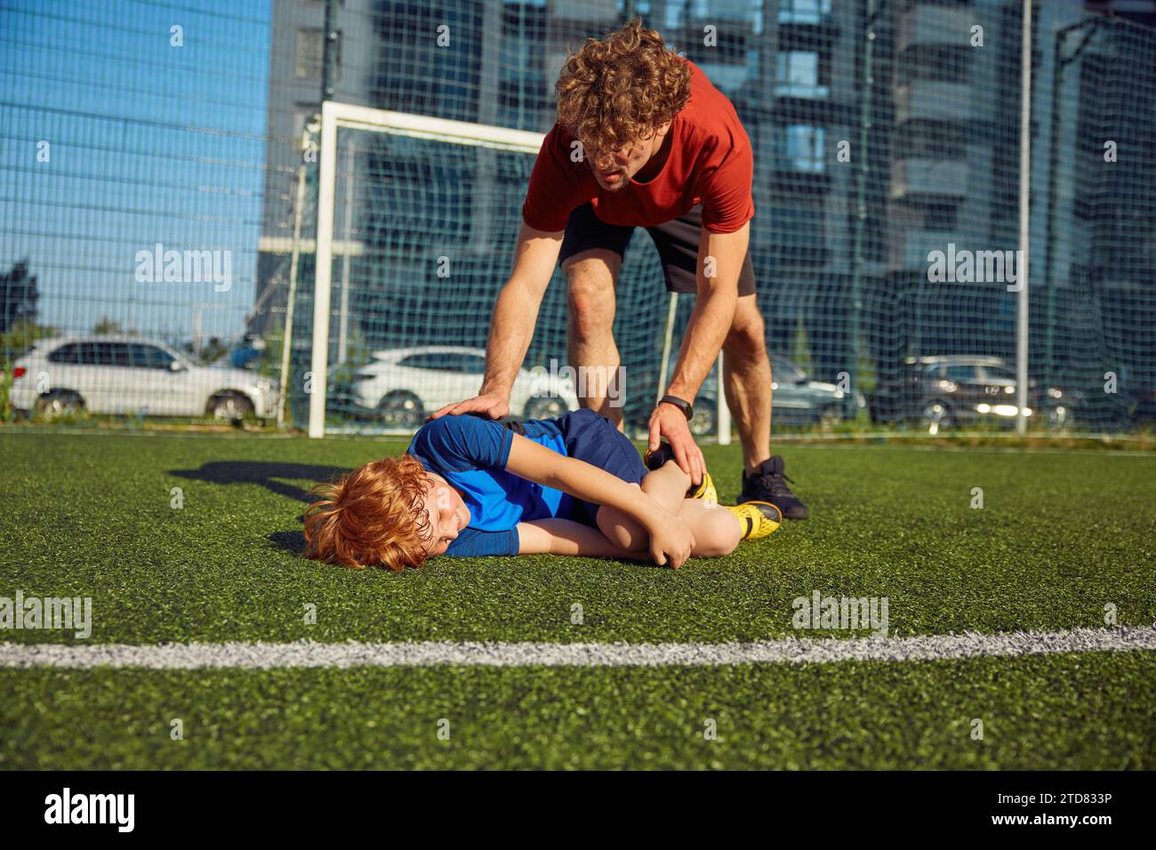 Boy child hurt his leg during training football match with father Stock ...