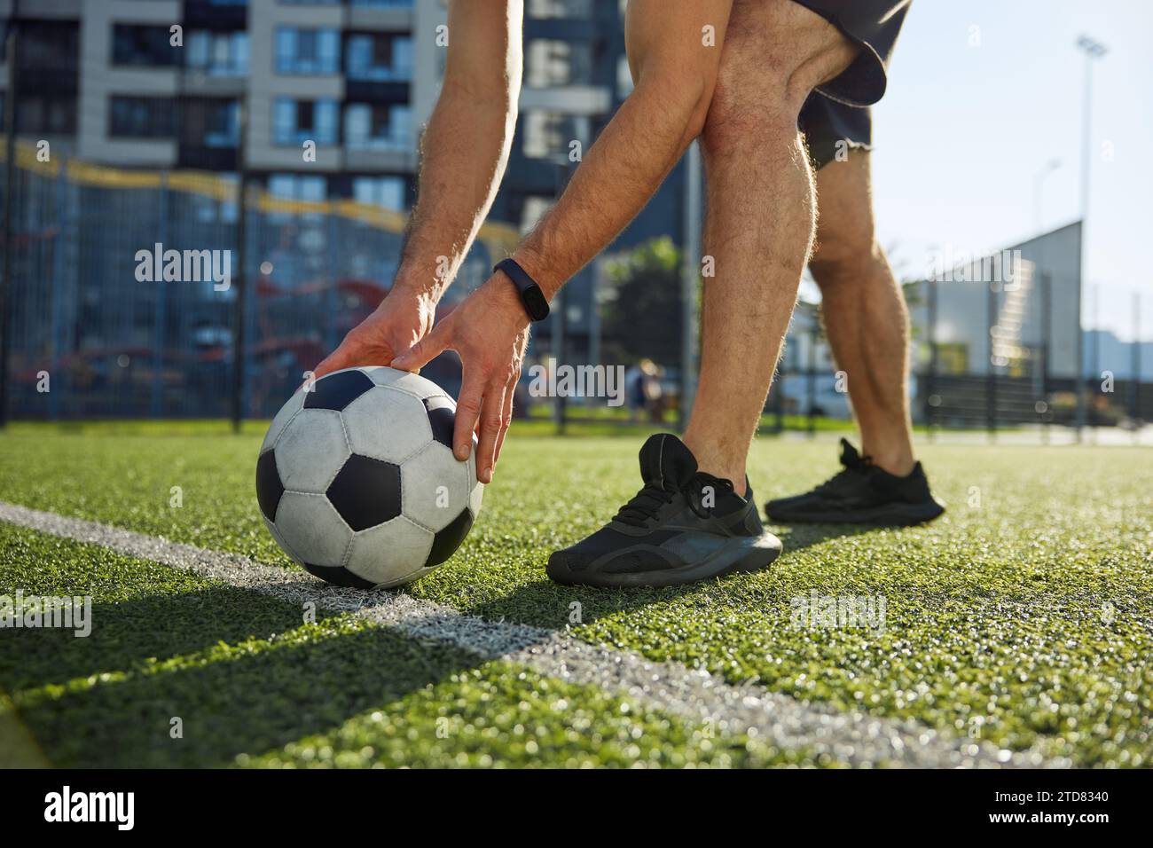 Male football player putting ball on strip line on center of soccer ...