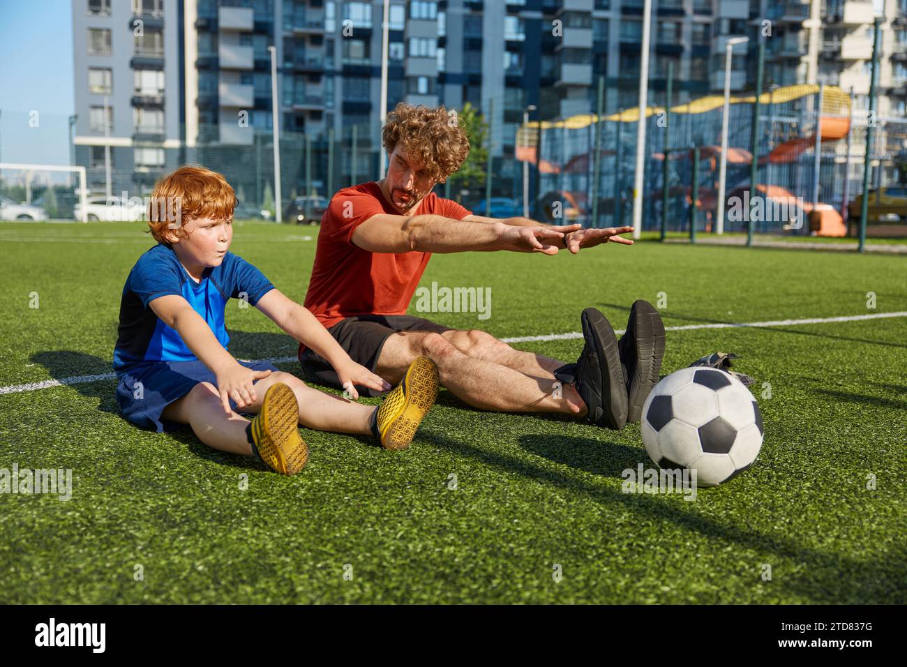 Father and son doing stretching exercise before playing football match Stock Photo - Alamy