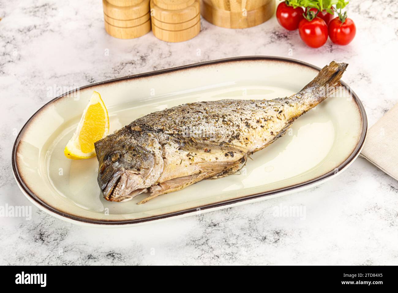 Baked Dorado fish served lemon slice Stock Photo - Alamy