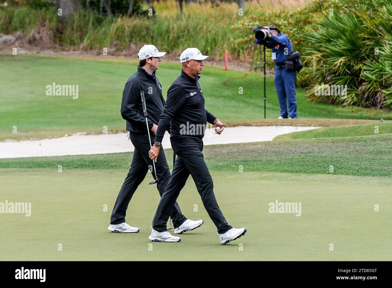 Stewart Cink and his son, Reagan Cink, walk on the green on the ninth ...