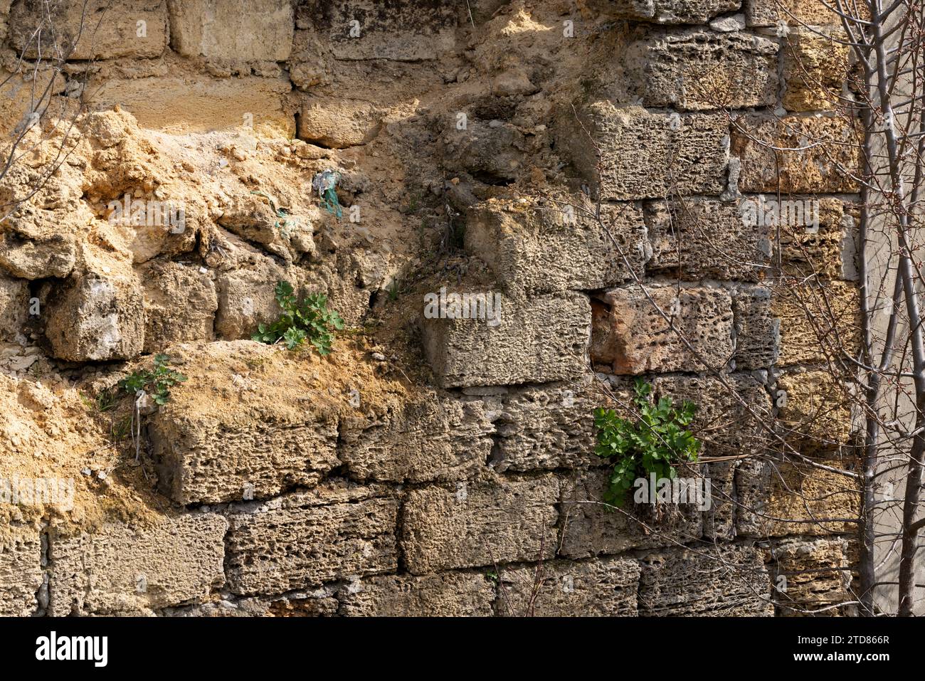 Broken wall of an old house nearby, traces of climate weathering ...