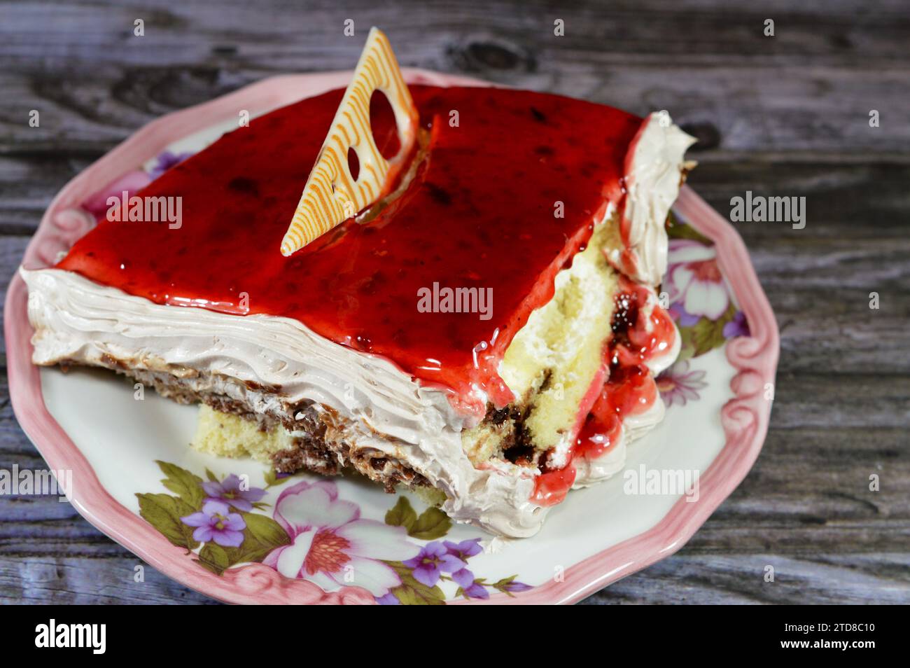 A quarter of a spongy creamy cake for celebrations topped with berries ...