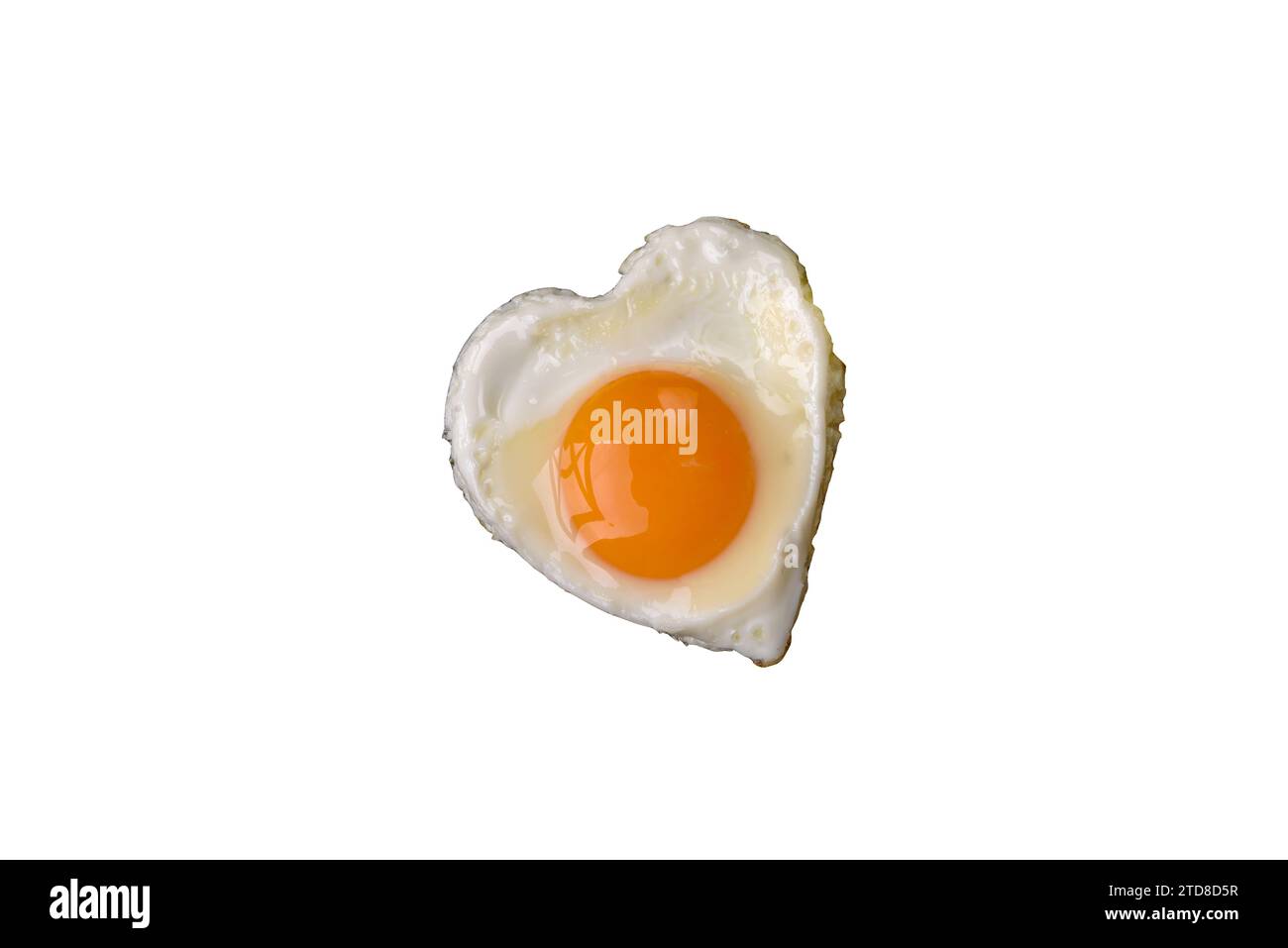 Two heart-shaped fried eggs on a black ceramic plate on a dark concrete background. Breakfast ...
