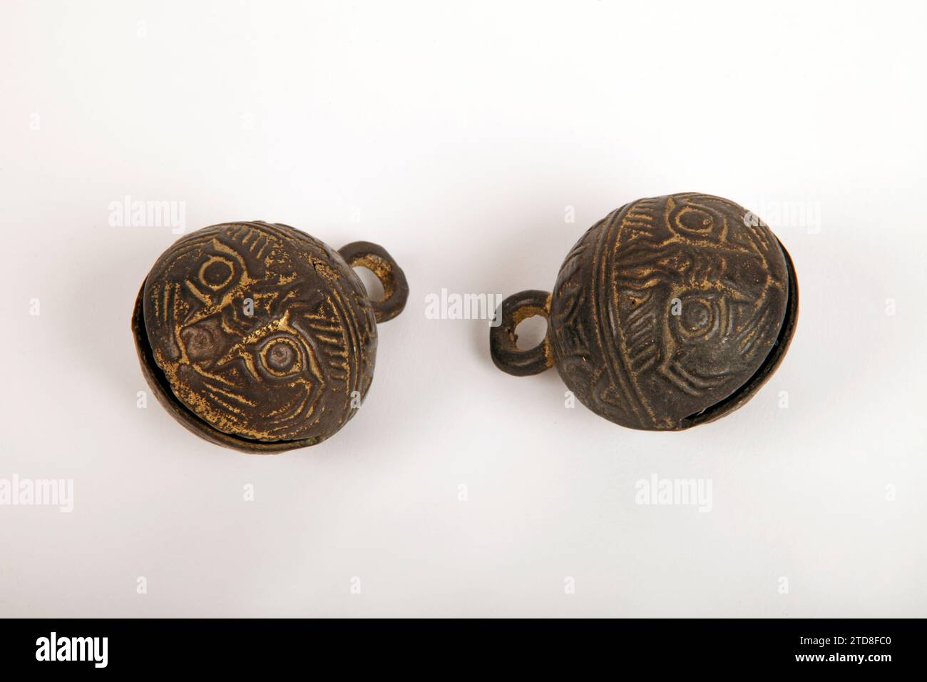 Pair of small Chinese bronze jingling bells.Decorated withy a face ...