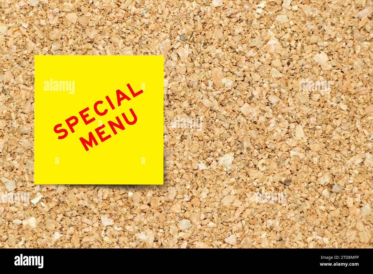 Yellow note paper with word special menu on cork board background with ...