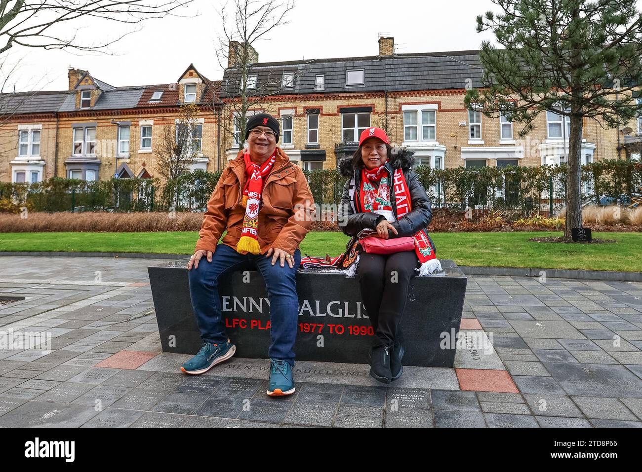 Liverpool fans sit on the Kenny Dalglish bench during the Premier ...