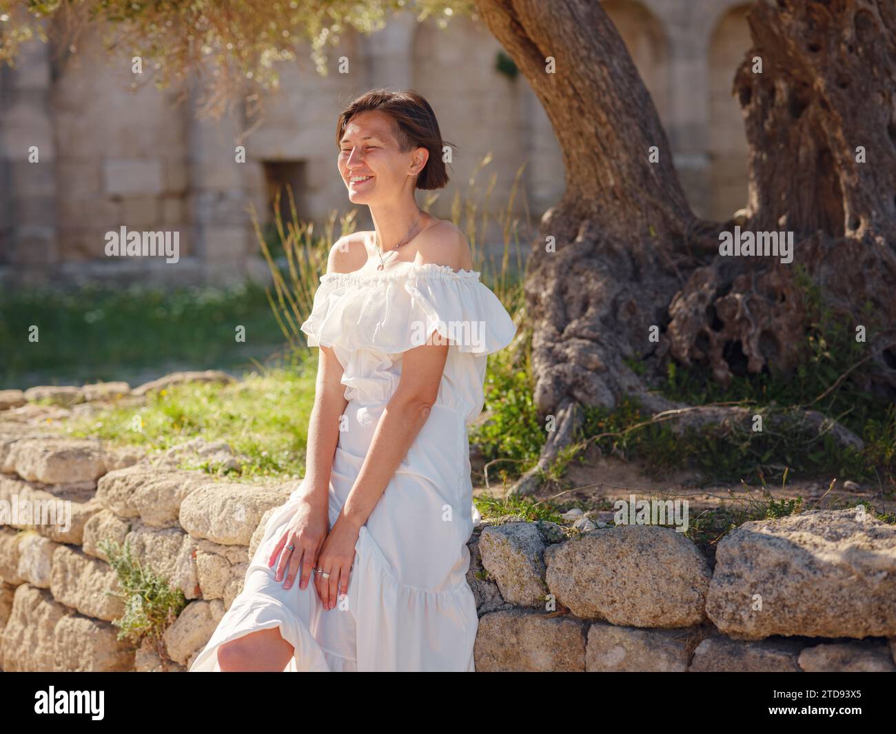 Beautiful Asian young woman in white dress outdoor. Acropolis of Rhodes ...