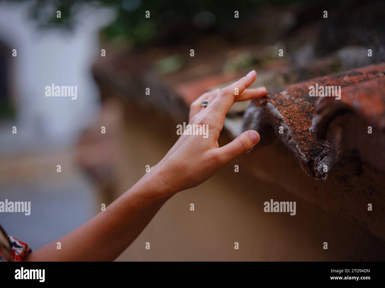 Female hand gently touches weathered tiles in old town of Kalechi ...