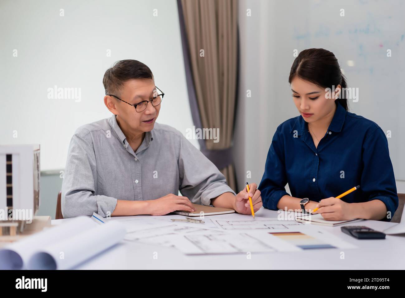 Two architects pointing on blueprint and analyzing about construction ...