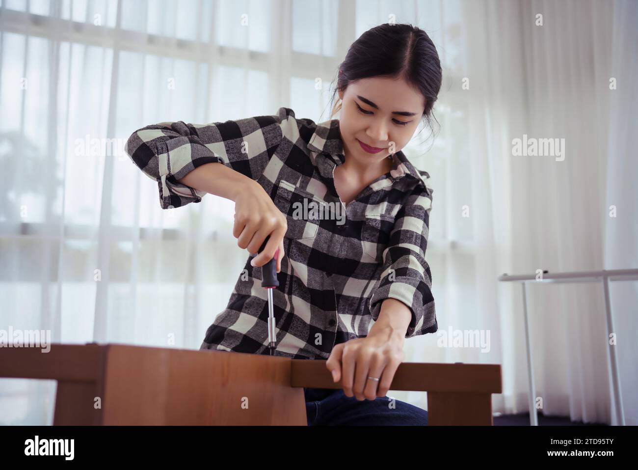 Women use screwdriver to installation screw for assembling and ...