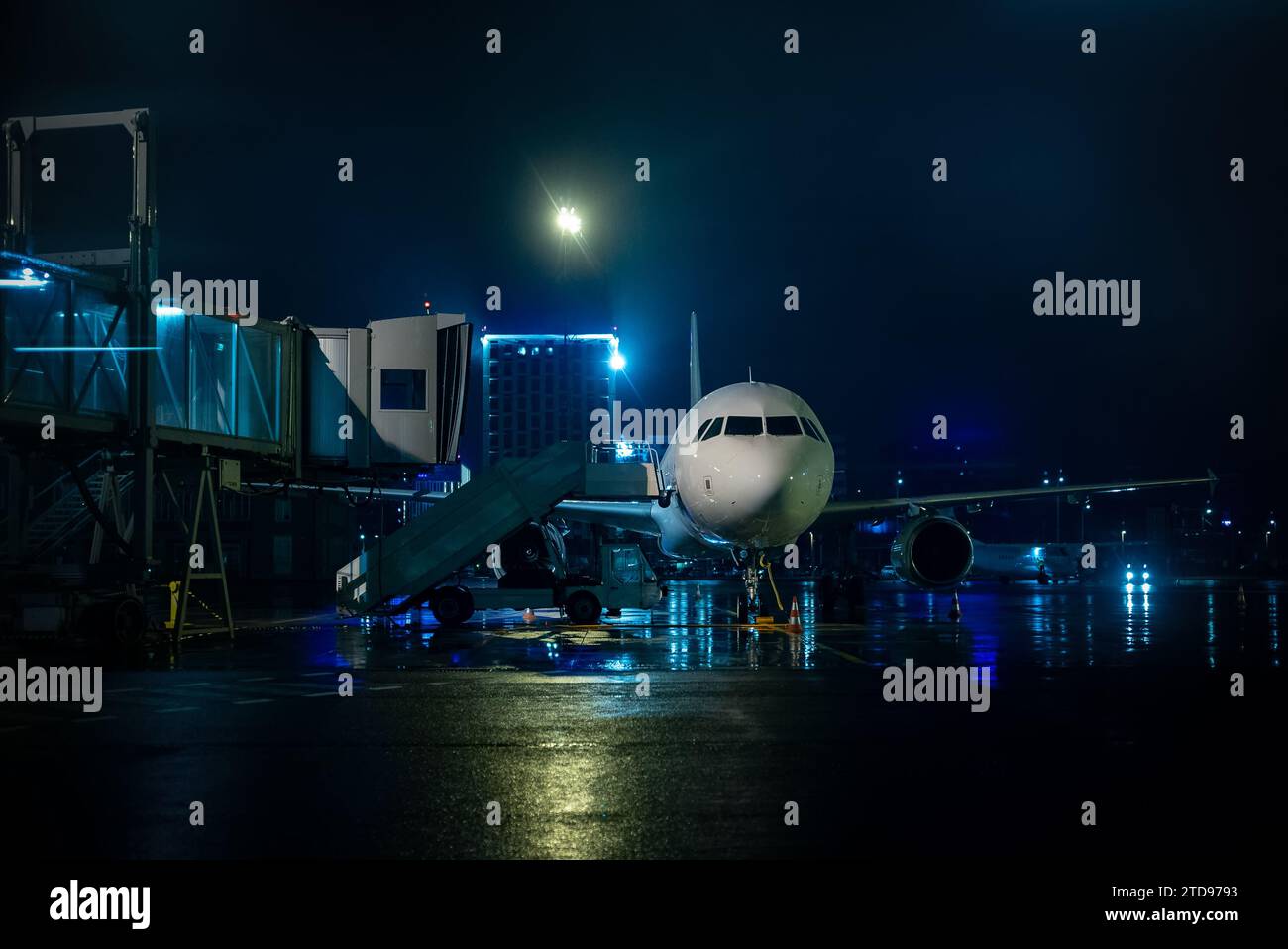 Airplane with a ramp at the airport at night Stock Photo - Alamy