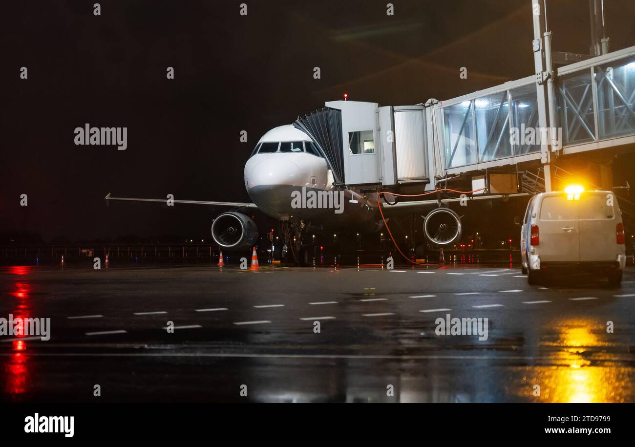 Airplane with a ramp at the airport at night Stock Photo - Alamy
