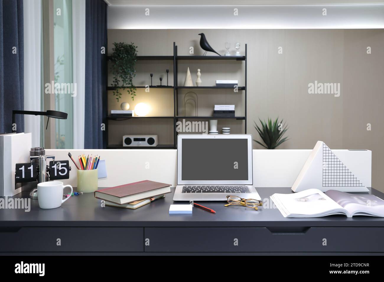 View of a room at home with a laptop with a blank screen on the desk ...