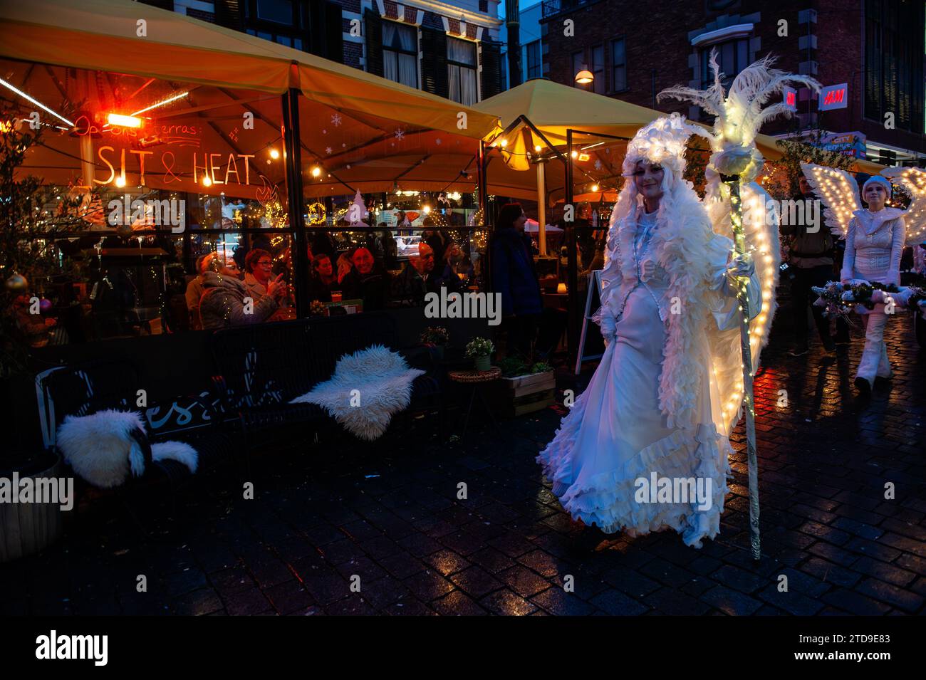 People sitting on the terraces watch the parade passing by. The ...