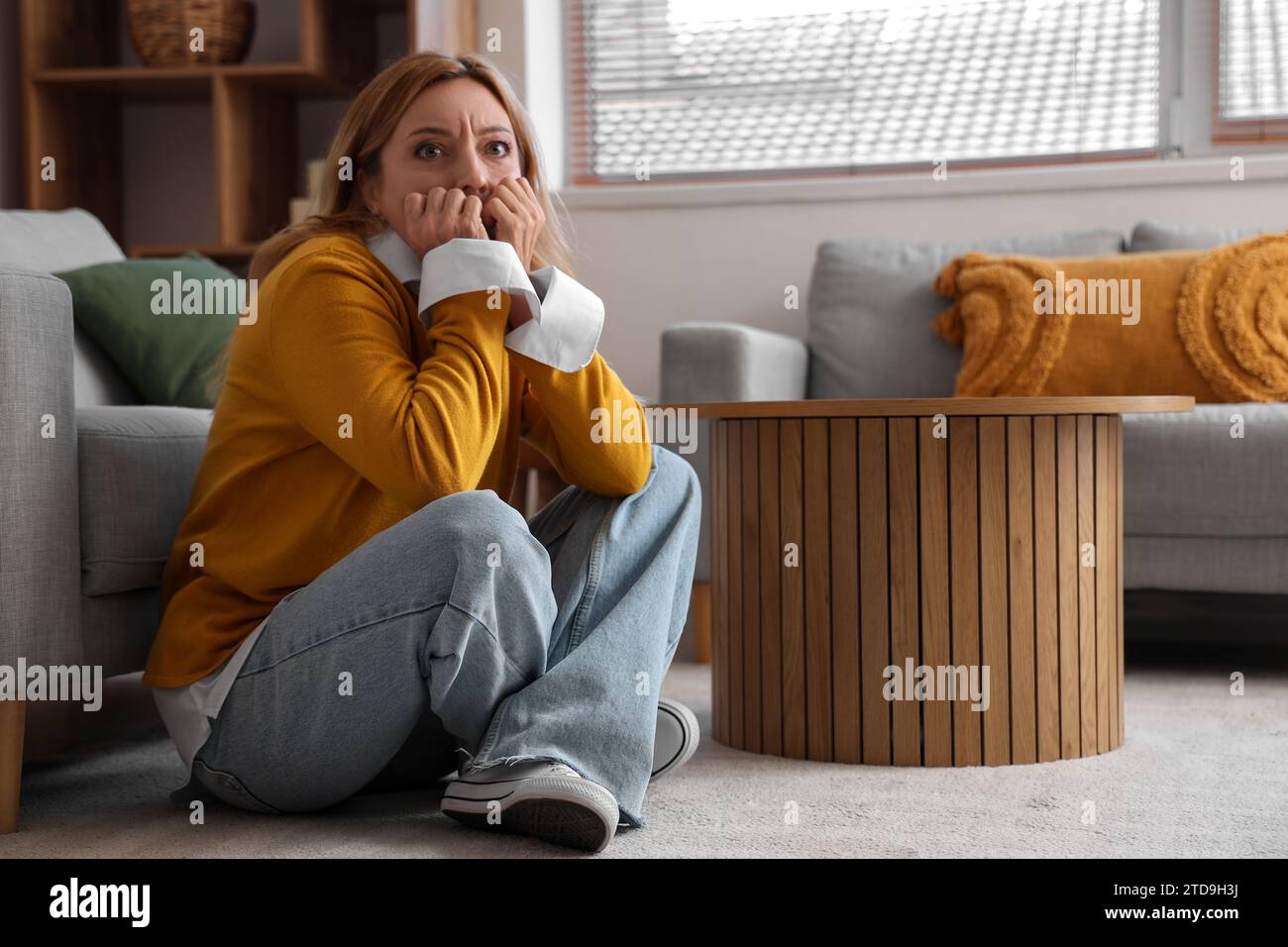 Scared mature woman at home Stock Photo - Alamy