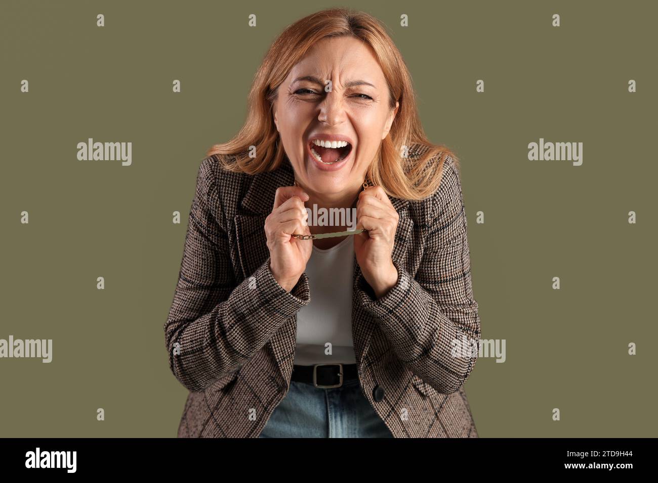 Scared mature woman on green background Stock Photo - Alamy