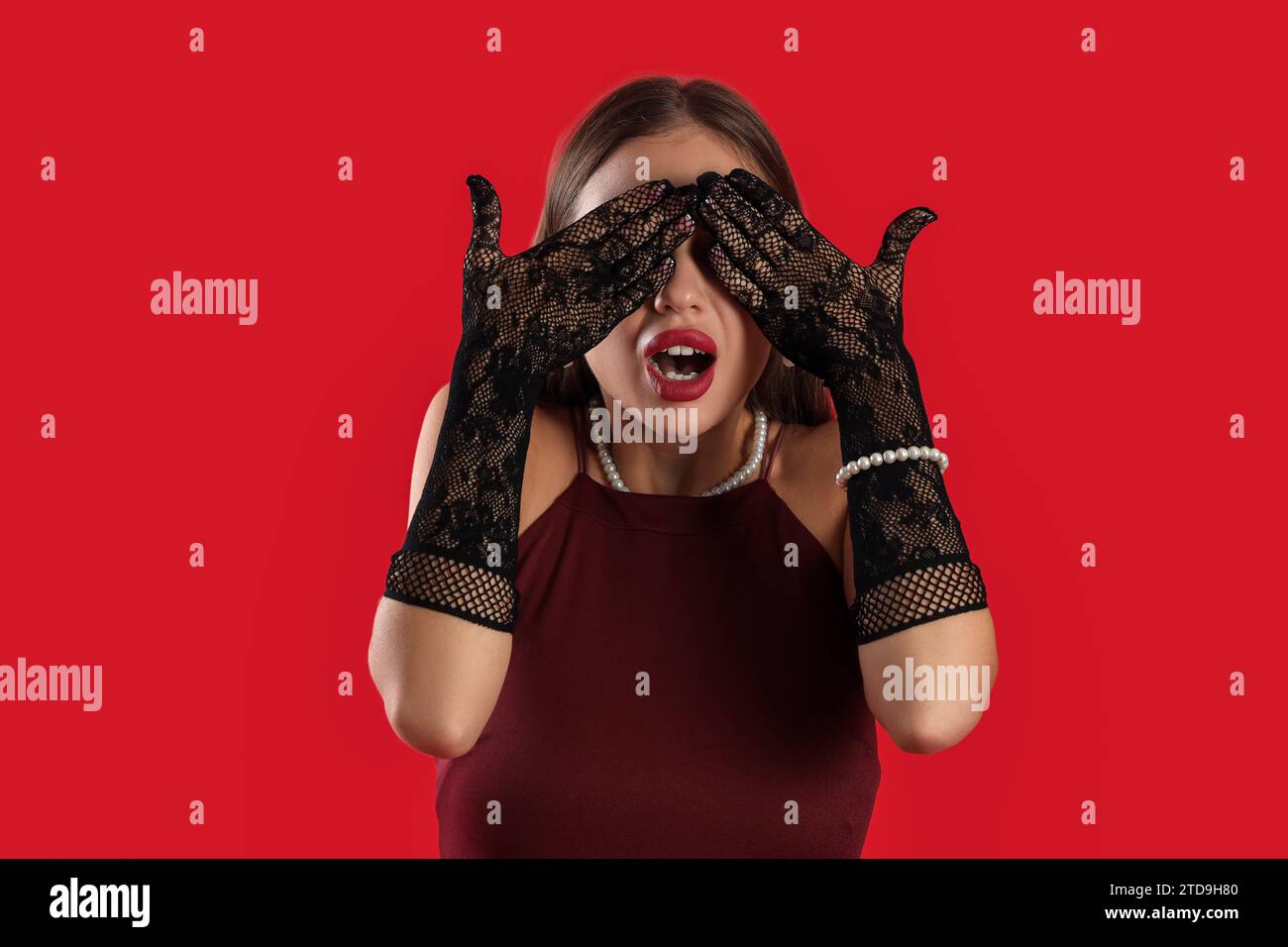 Scared young woman covering eyes on red background Stock Photo - Alamy
