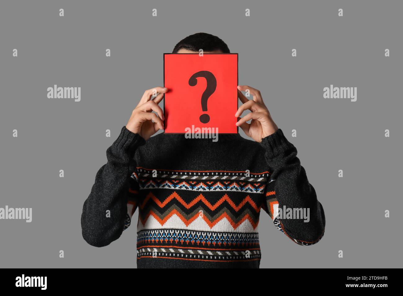 Young man holding paper with question mark on grey background Stock ...