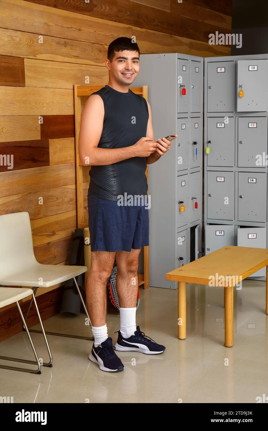 Sporty young man with mobile phone in locker room Stock Photo - Alamy